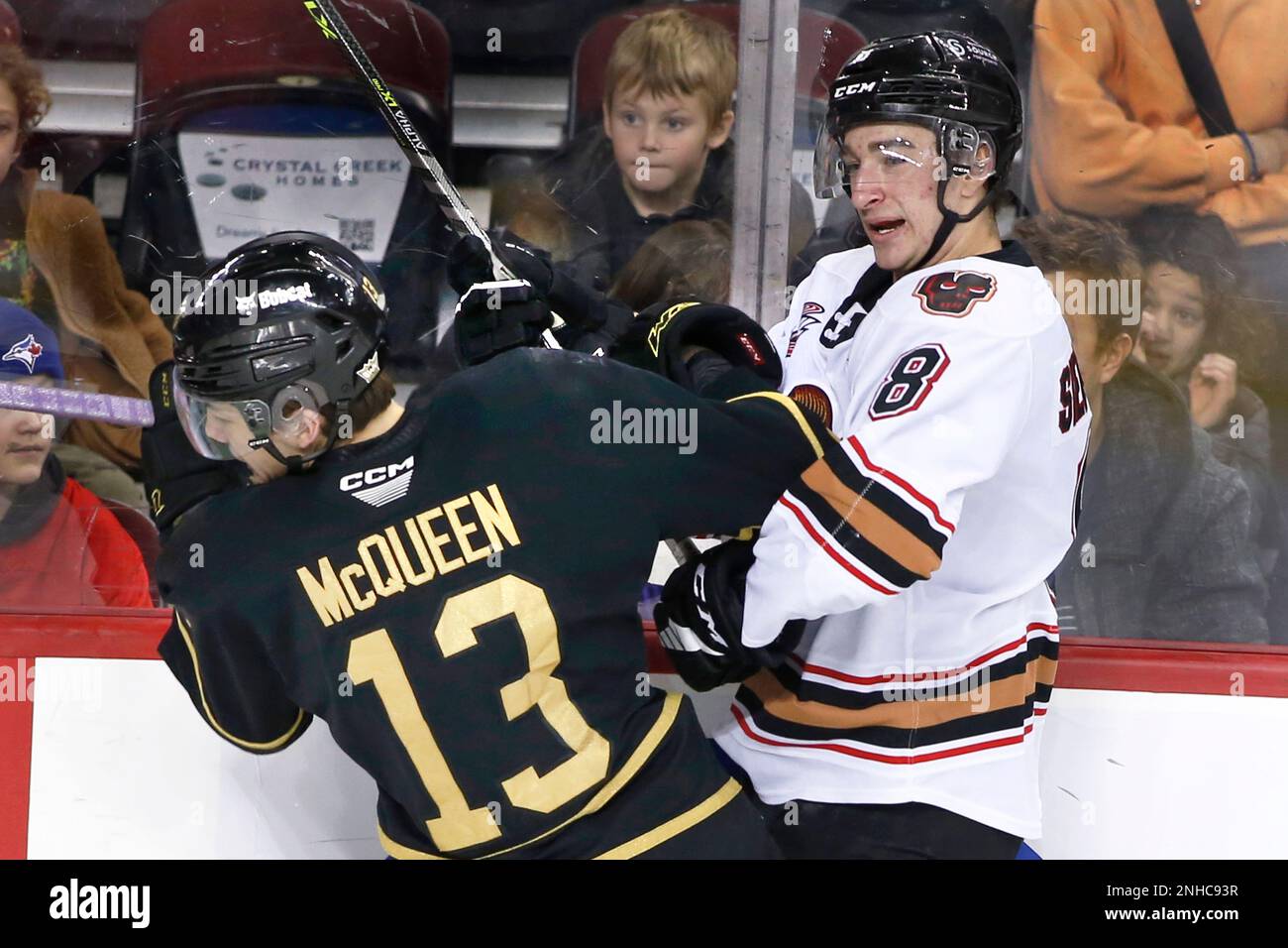 Brandon Wheat Kings player Roger McQueen, lt, hits Calgary Hitmen ...