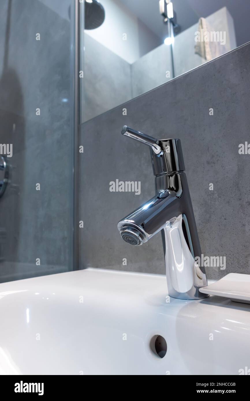 A chrome faucet in an elegant bathroom. Object photographed from below ...