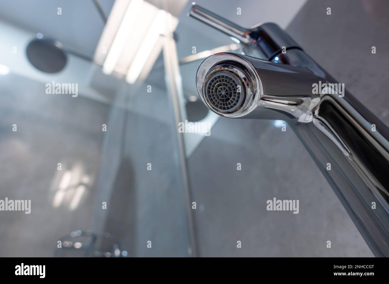 A chrome faucet in an elegant bathroom. Object photographed from below ...