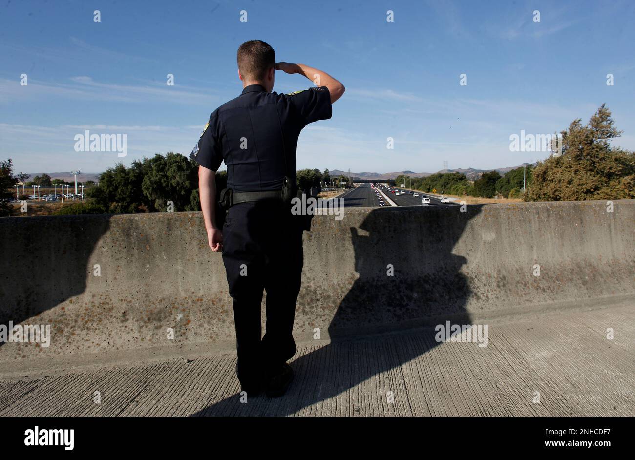 Sgt. Andrew White, with Suisun CIty Police, salutes the motorcade as it ...