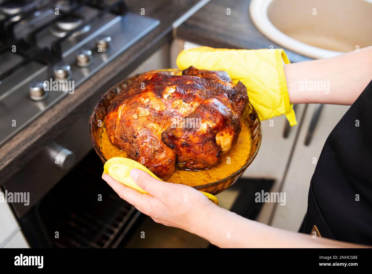 Woman taking roast dinner out of oven hi-res stock photography and ...