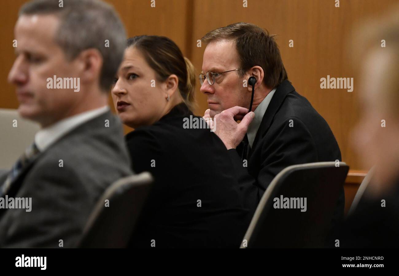 Mark Jensen, third from left, puts on a listening device as he sits ...