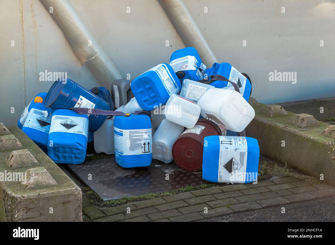 blue empty plastic barrels on a dumping site on the quay near a ship ...
