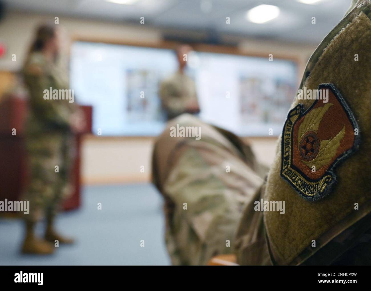 Members of the 66th Air Base Group listen as Col. Taona Enriquez, 66 ABG commander, and Chief ...