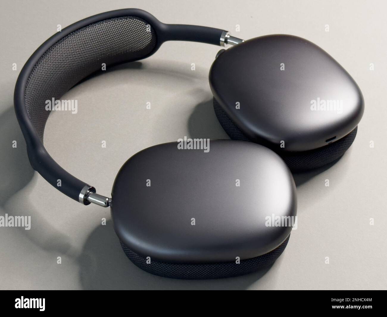 a beautiful pair of space gray Apple Airpods Max headphones, on a clear ...