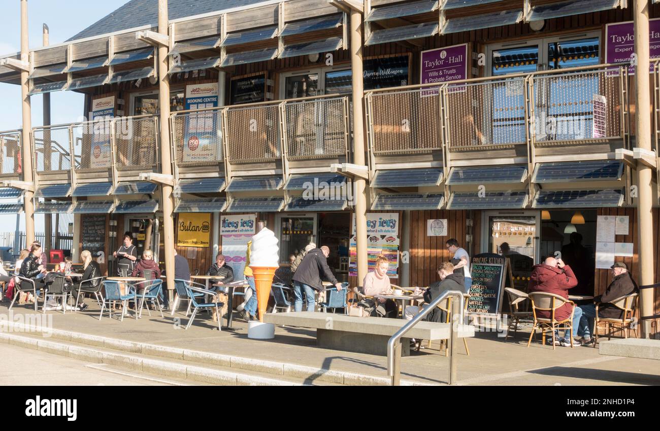People sitting eating outside cafes at The Waterside in Seaham Harbour ...