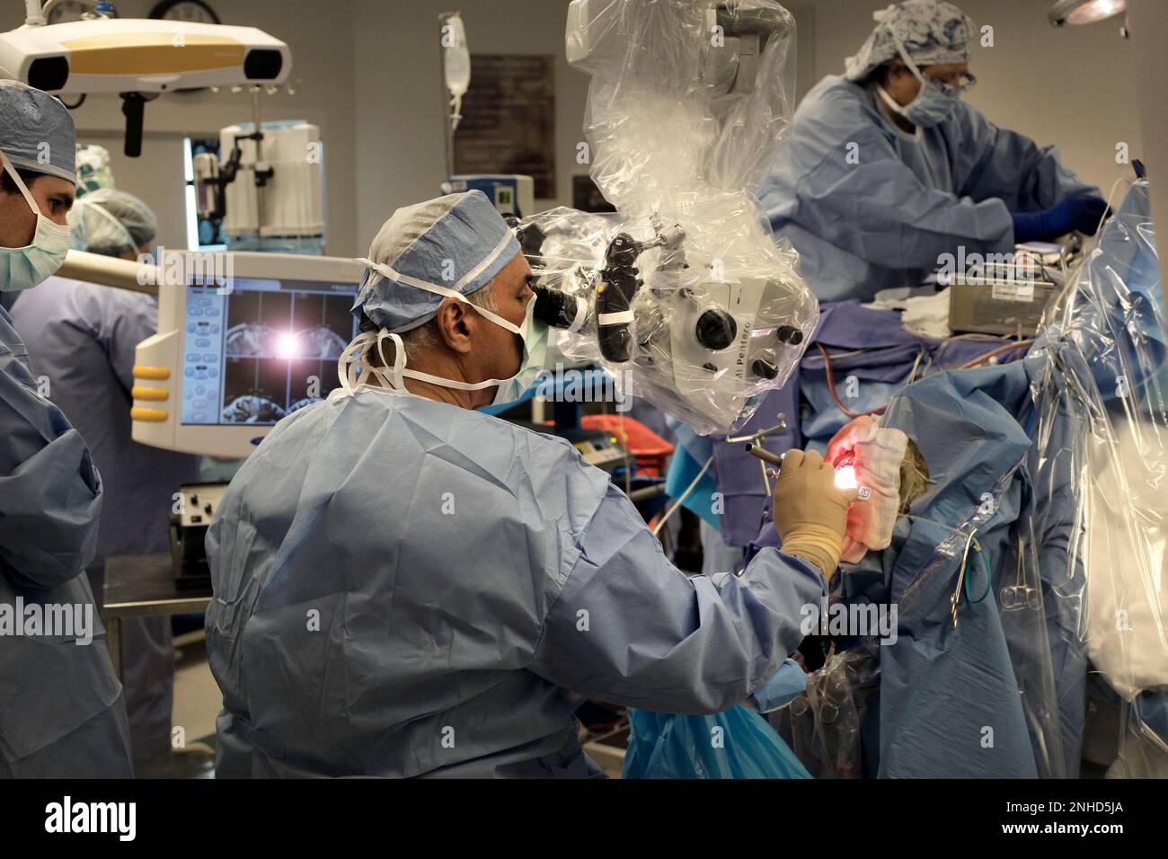 Dr. Mitchel Berger, (center) performs brain surgery to remove a tumor ...