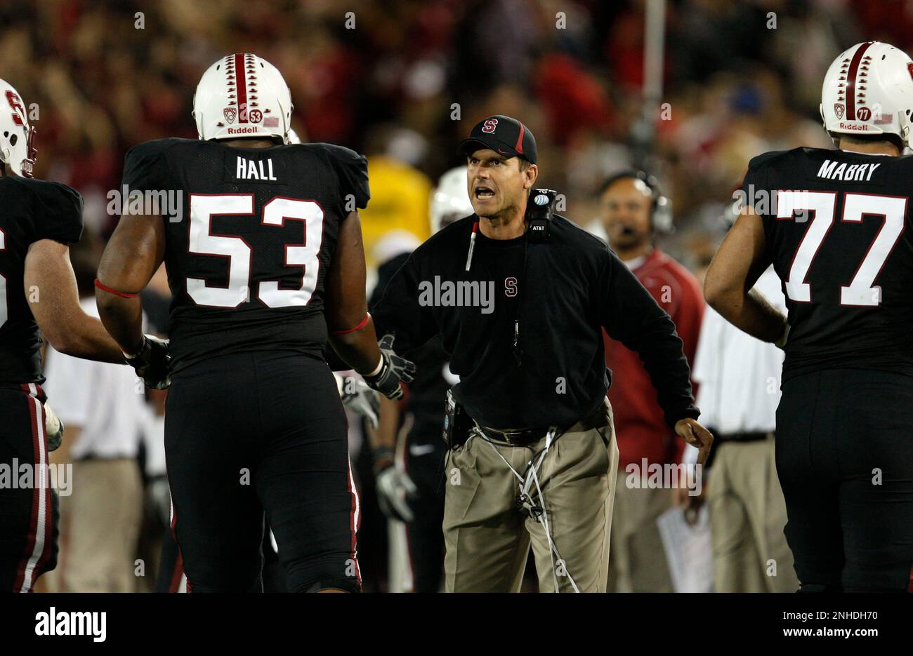 Stanford head coach Jim Harbaugh praises his team as they come off the ...