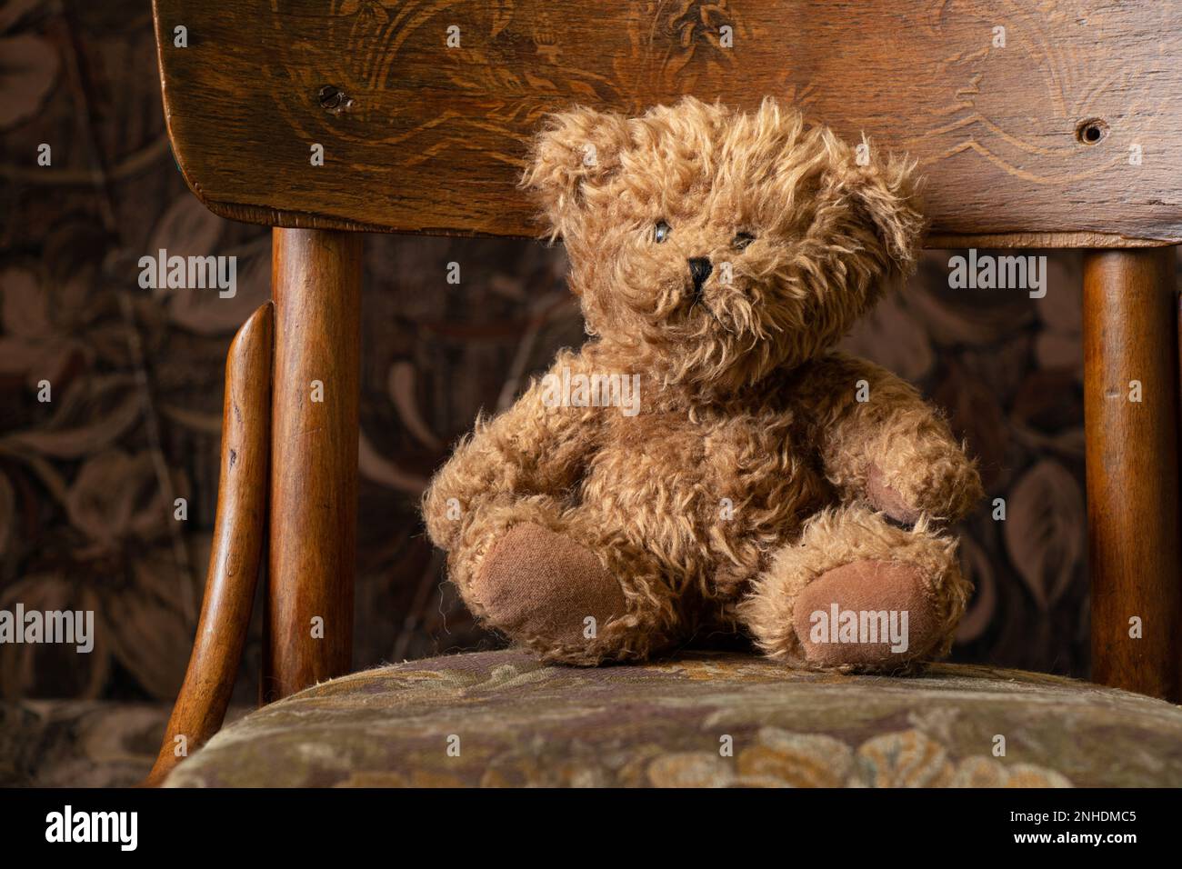 brown teddy bear sits on an old chair at home, children's toy Stock ...
