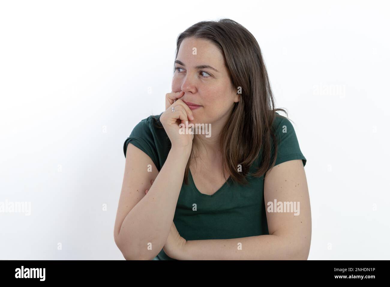 Pensive young brunette woman gazing at the sky with her hand on her ...