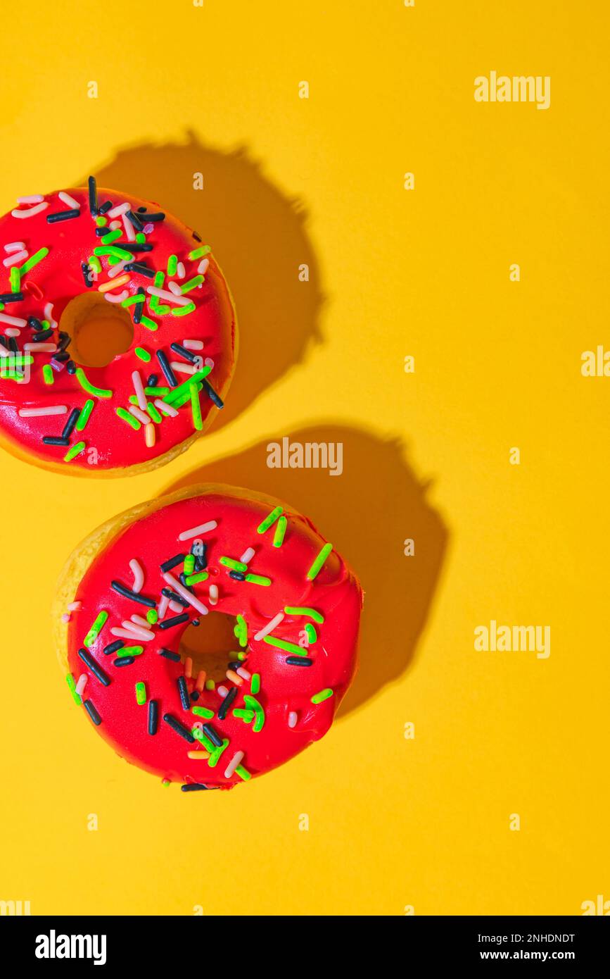 Donuts on yellow background with red icing, food photography Stock ...