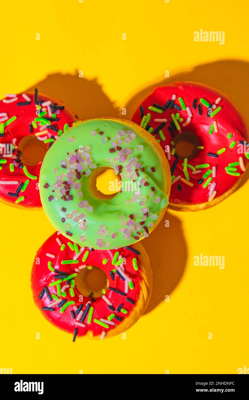 Donuts on yellow background with red and green icing, food photography ...