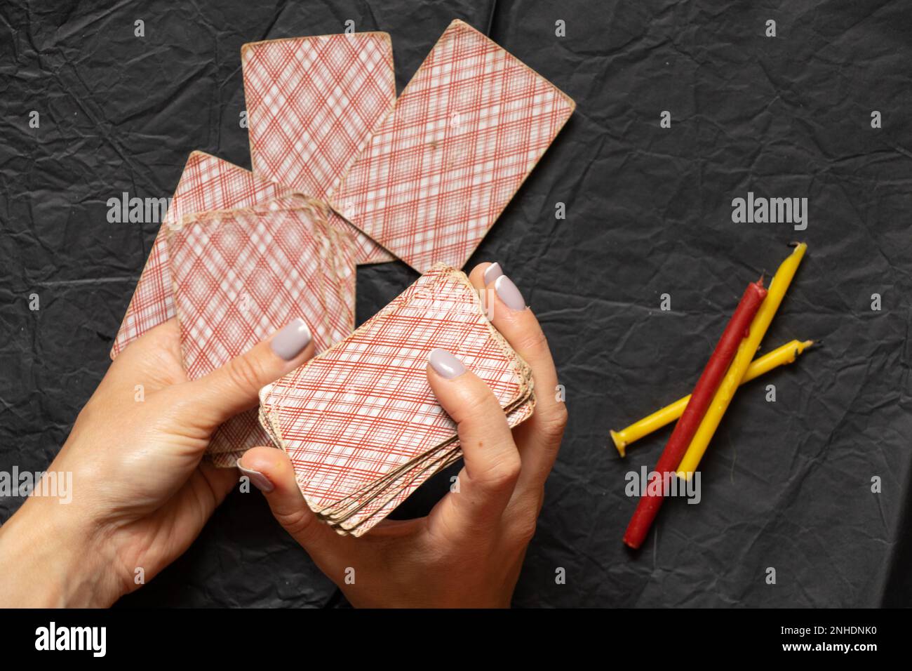 cards in the hands of a fortune teller and candles on the table ...