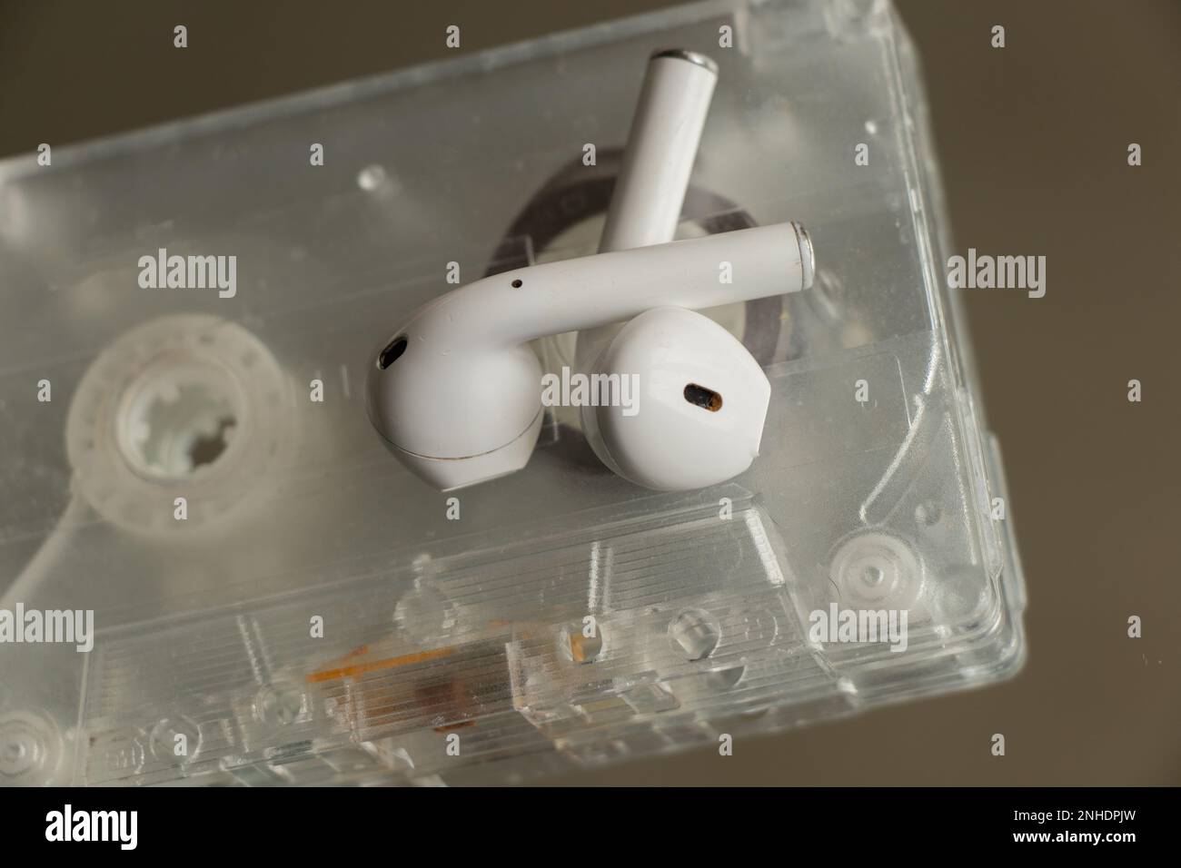 old music cassette and wireless headphones on an isolated background ...