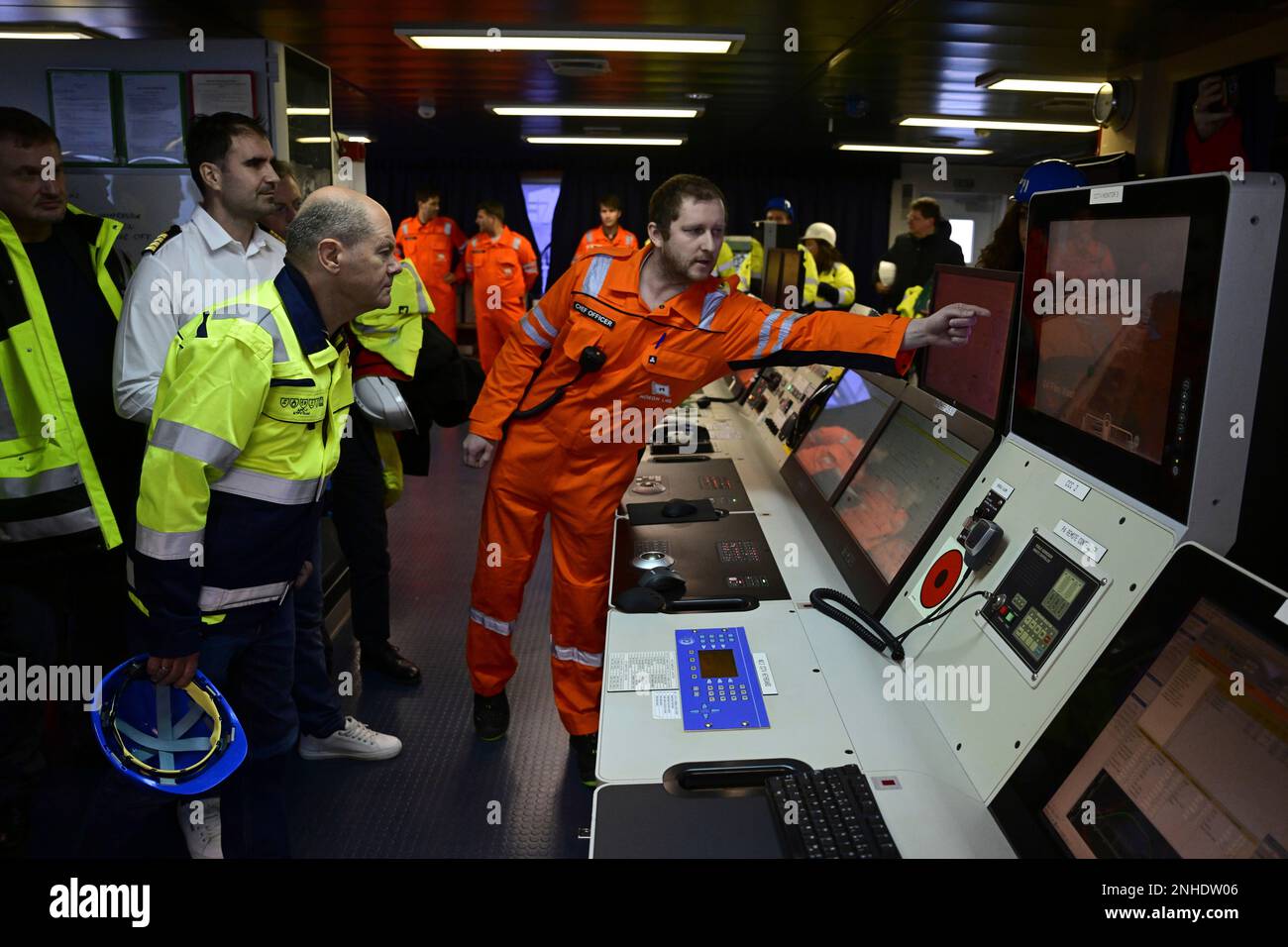 Chief officer Ingars Perkons shows German Chancellor Olaf Scholz, left ...
