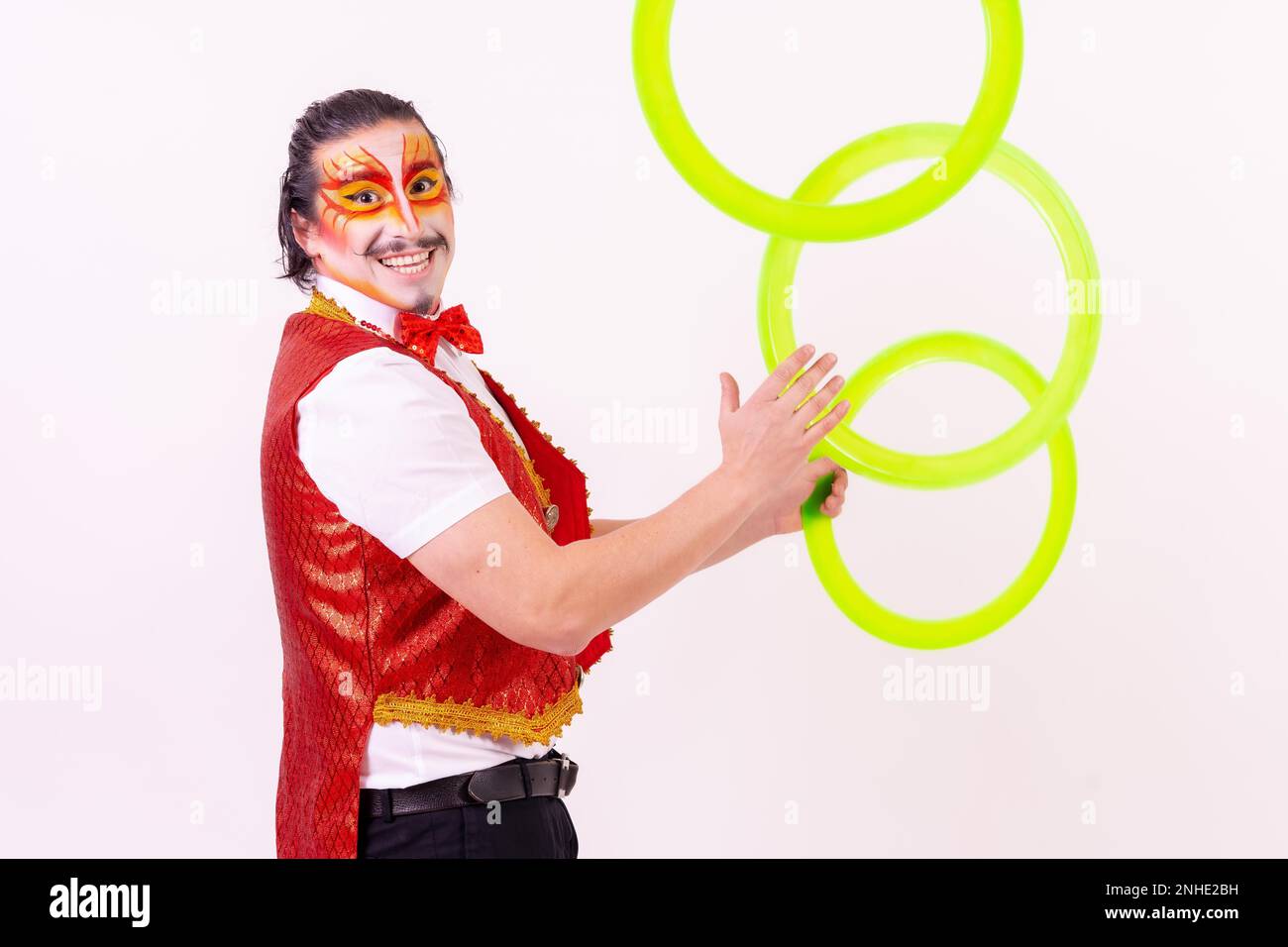 Smiling juggler juggling hoops isolated on white background Stock Photo - Alamy