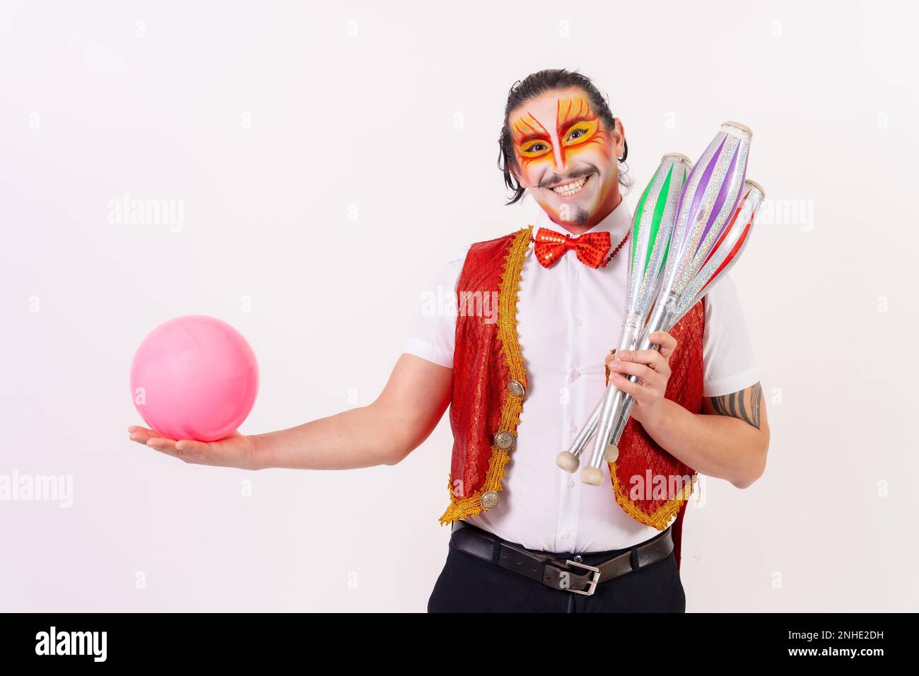 Portrait of a juggler smiling with juggling mallets and a ball isolated ...