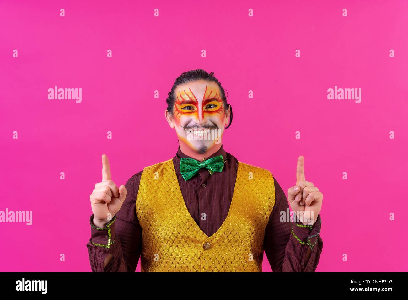 Clown with white face makeup showing empty space on pink background ...