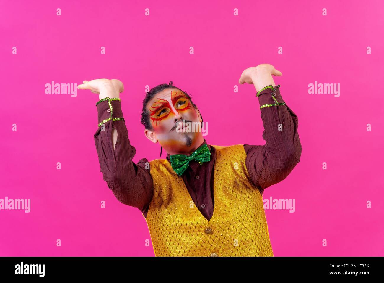 Clown with white face makeup showing empty space on pink background ...
