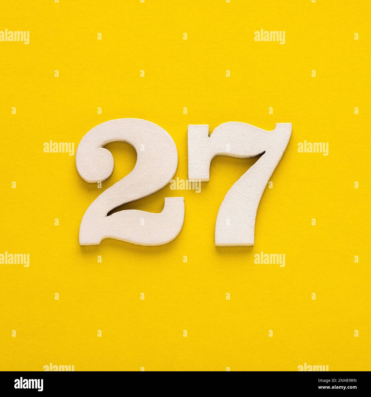 Number 27 - Two figures in white on a yellow background Stock Photo - Alamy