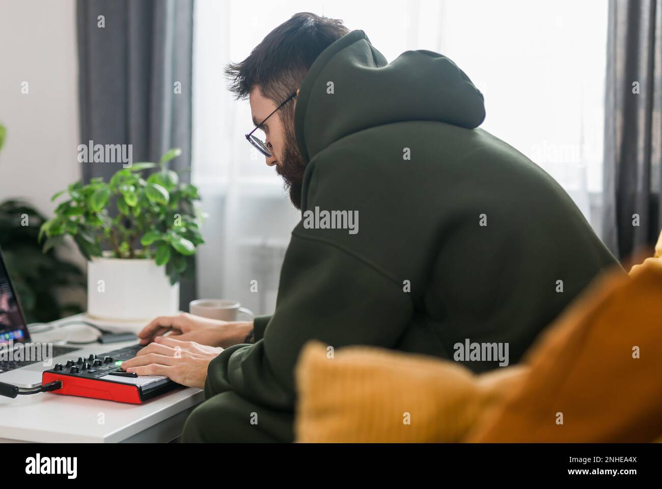 Man recording electronic music track with portable midi keyboard on ...