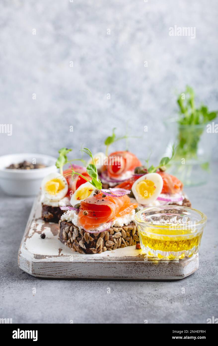 Close-up of sandwich with dark rye bread, cream cheese, salmon, onion ...