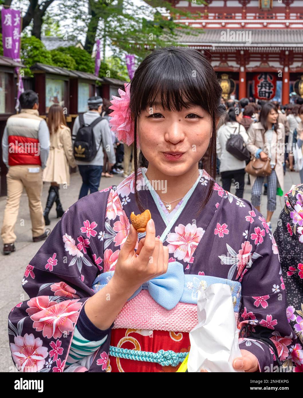 Tokyo Japan. A girl tasting sweets in the streets of Asakusa Stock ...