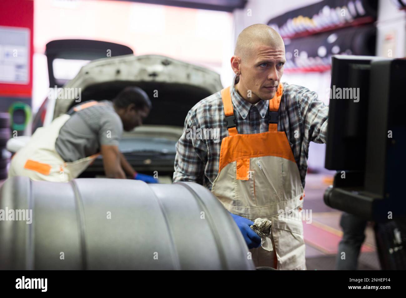 Mechanic balancing wheel with machine balancer at auto service Stock ...