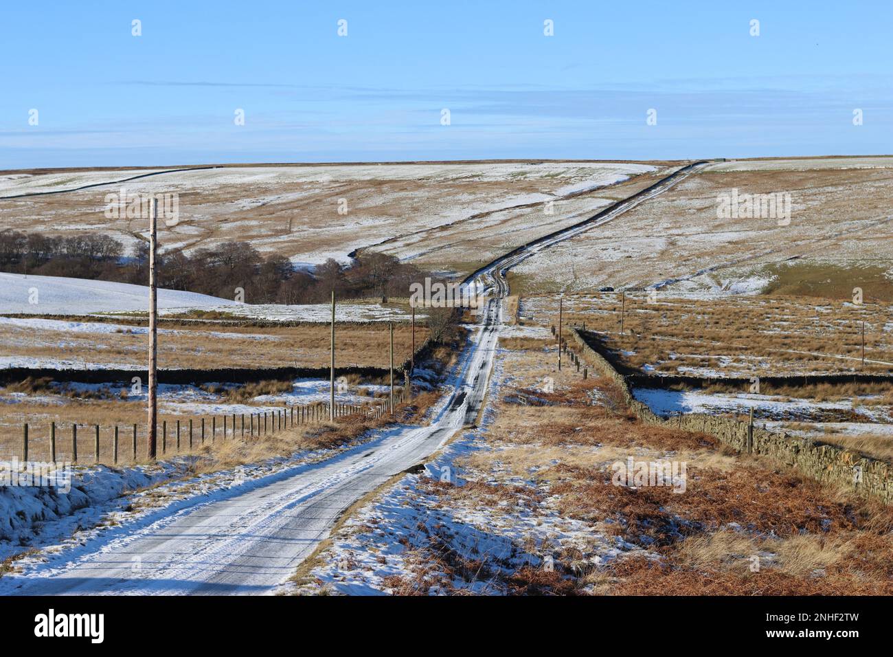 Snow covered rural road winding through a frozen upland landscape in ...