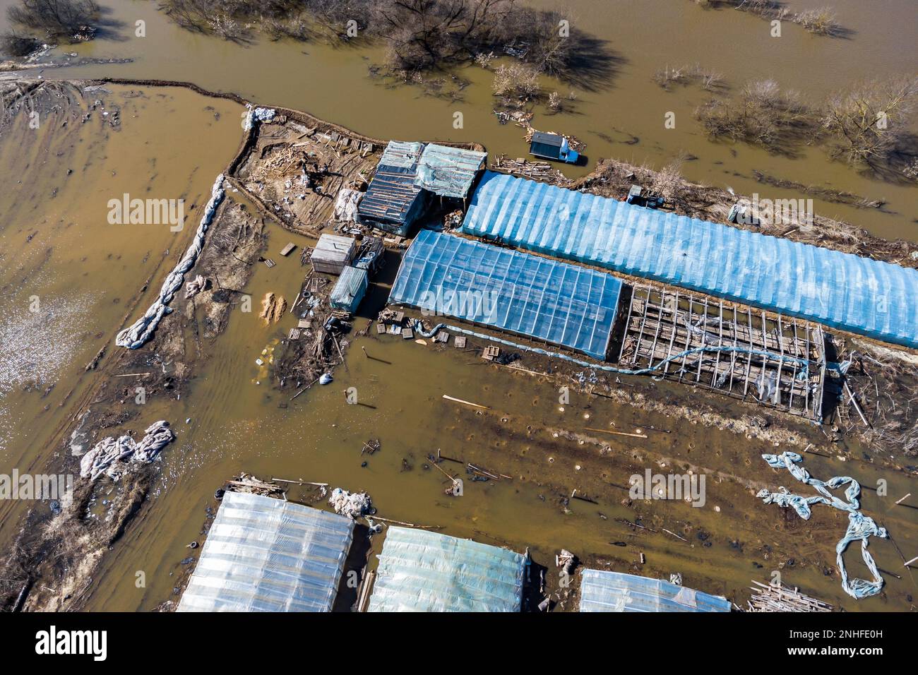 Agricultural farm with greenhouses in a field flooded during a strong ...