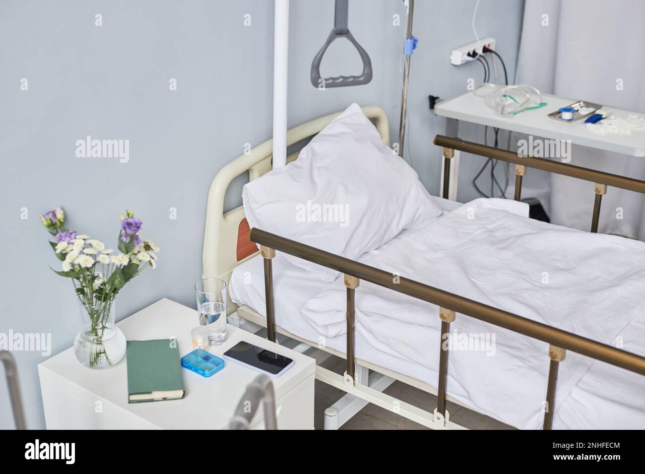 Background image of bed in hospital room interior with flowers on ...