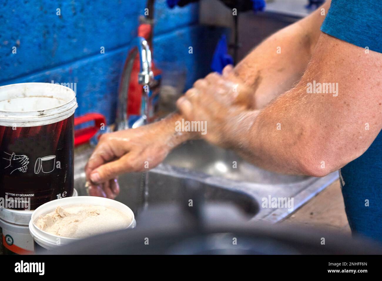 A mechanic washing his hands and arms after work with a very efficient ...