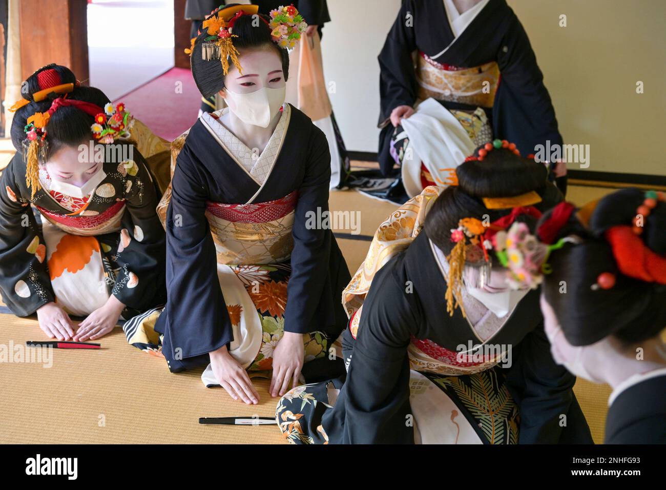 Kimono-clad geisha and maiko (geisha apprentice), wearing a face mask ...
