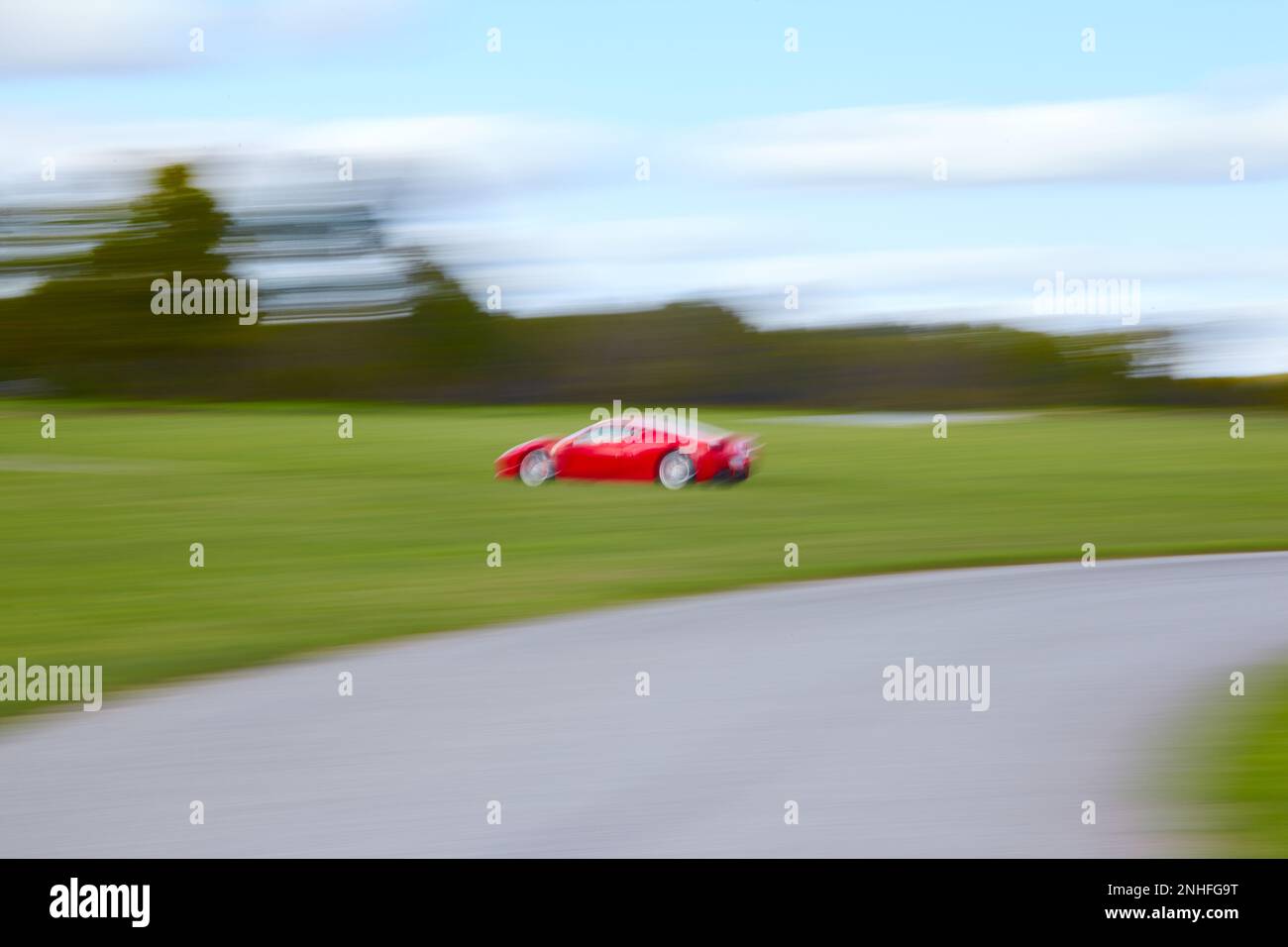 A red Ferrari running on a racing circuit with motion blur Stock Photo ...