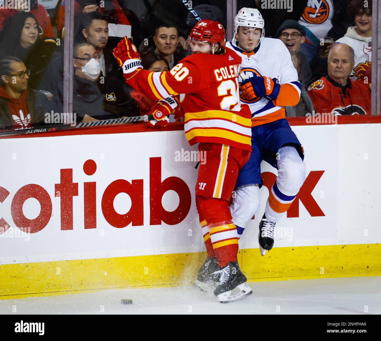 New York Islanders defenseman Noah Dobson, right, is checked by Calgary ...