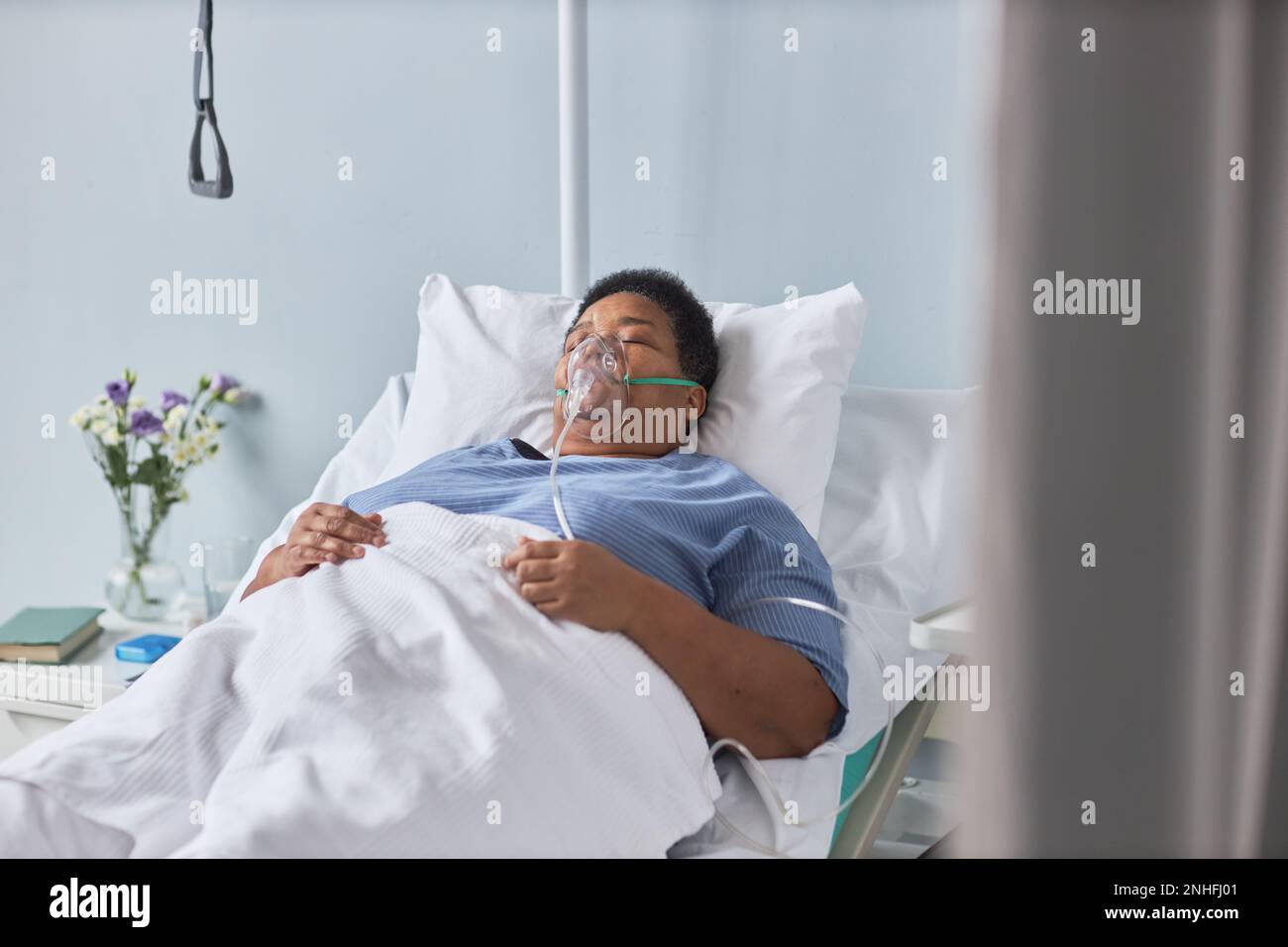 Portrait of senior African American woman laying on bed in hospital ...