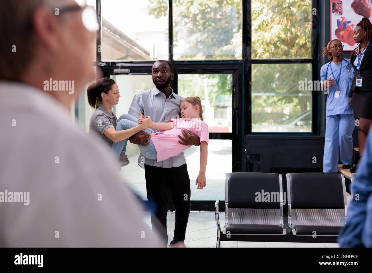 Worried african american dad holding unconscious little daughter in ...