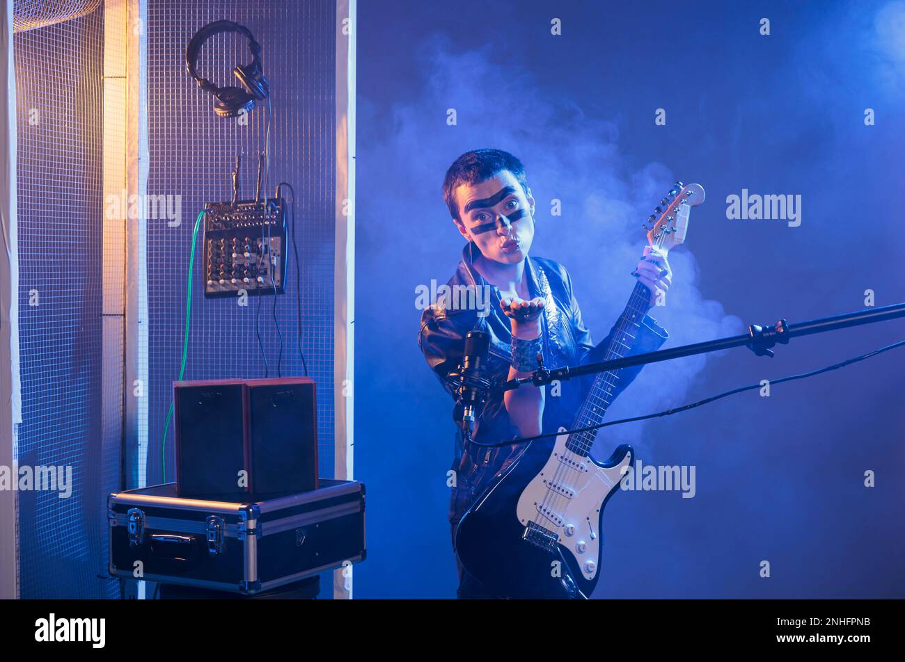 Punk rocker blowing air kisses and acting flirty, playing guitar and ...
