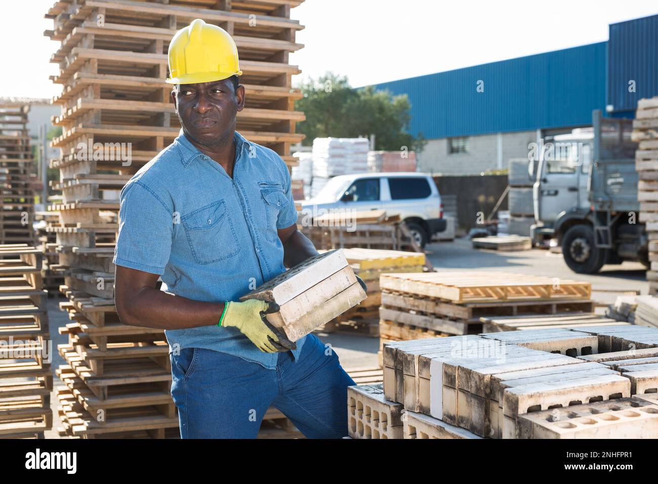 Worker stacking bricks in warehouse of building materials clpseup Stock ...