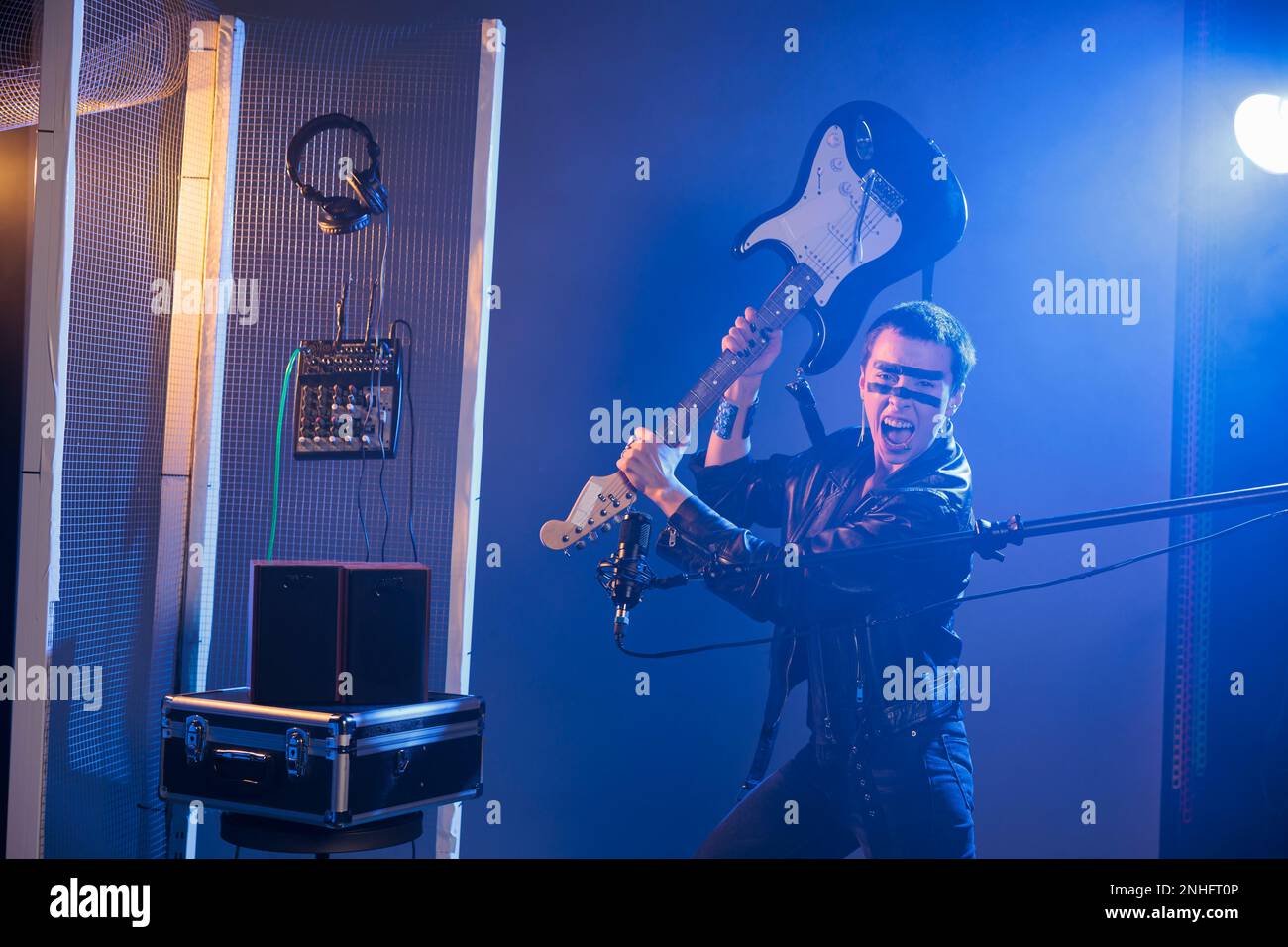 Cool stylish musician holding bass guitar to smash and act crazy ...