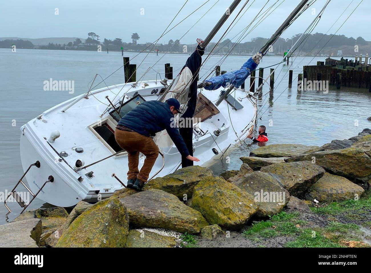 Two men tend to a sailboat that broke anchor at Porto Bodega and wound ...