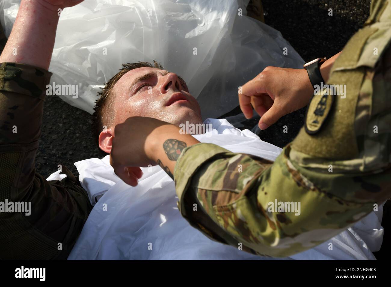 A combat medic covers Spc. Grayson Vaughn, a military policeman with ...