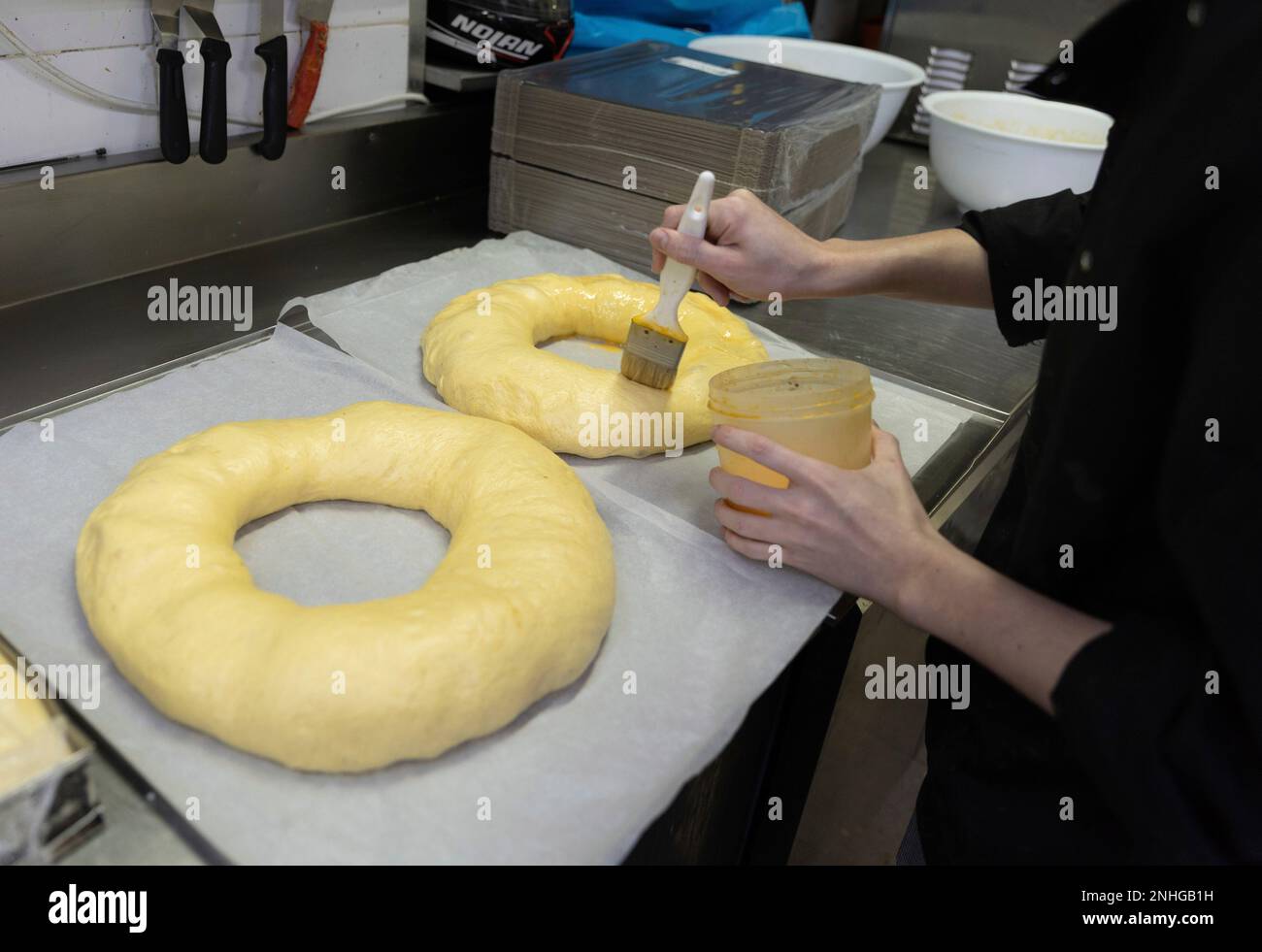 A pastry chef pours oil on a roscón at the Nunos bakery on January 2 ...