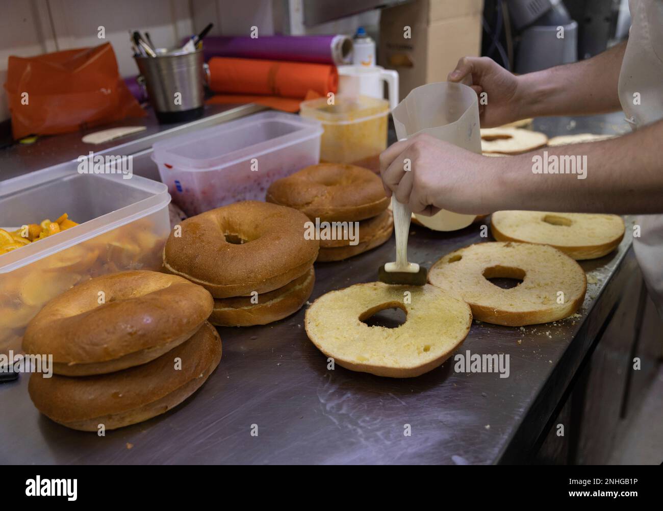 A pastry chef pours oil on a roscón at the Nunos bakery on January 2 ...