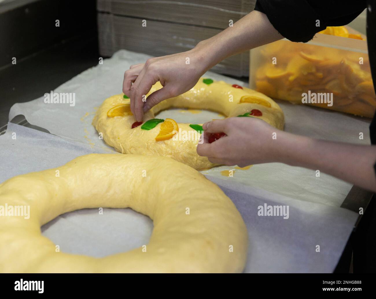 A pastry chef decorates a roscón at the Nunos bakery on January 2, 2023 ...