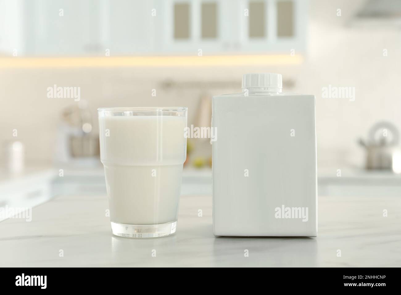 Carton box and glass of milk on table in kitchen Stock Photo - Alamy
