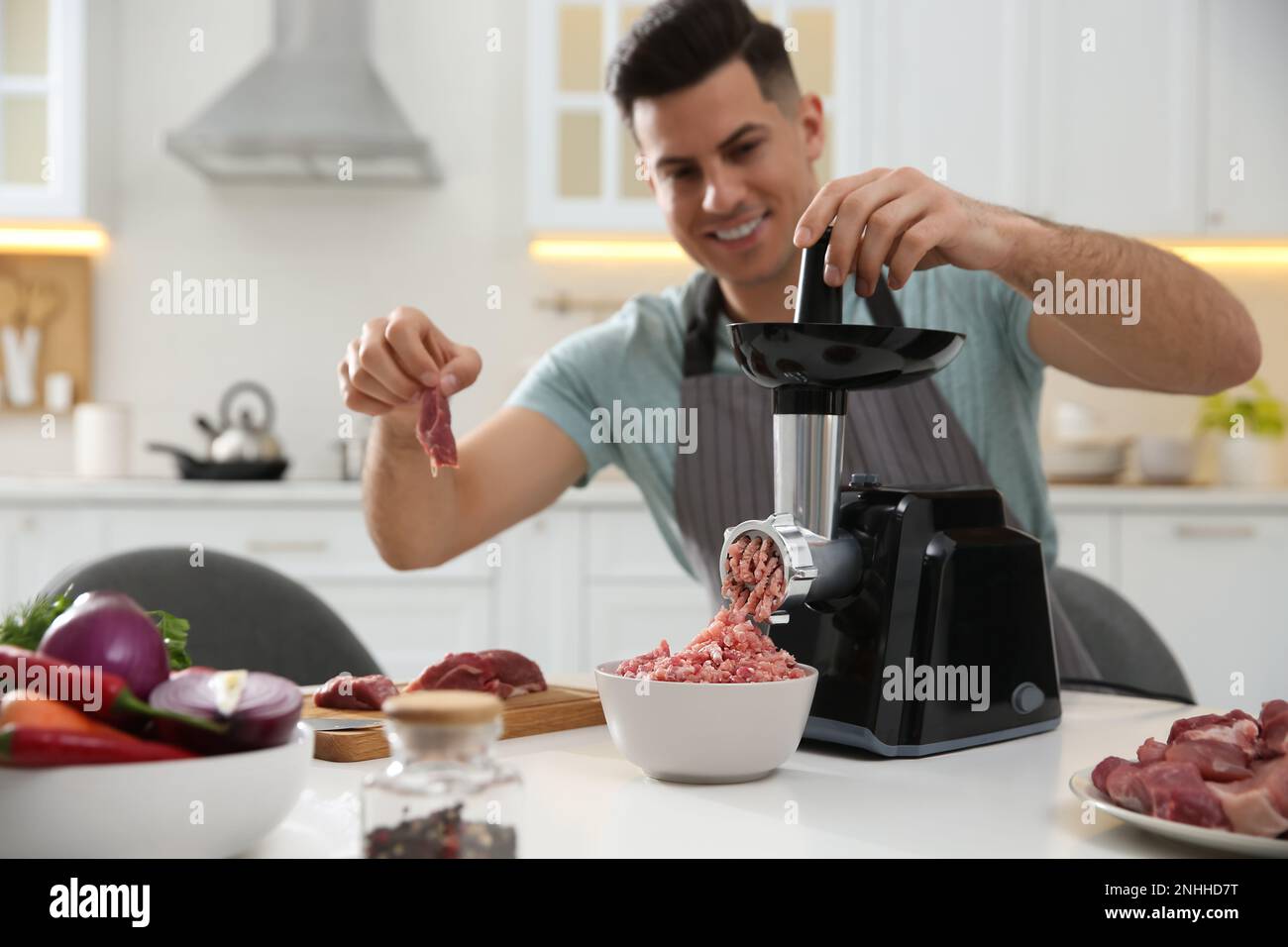 Man using modern meat grinder in kitchen Stock Photo - Alamy