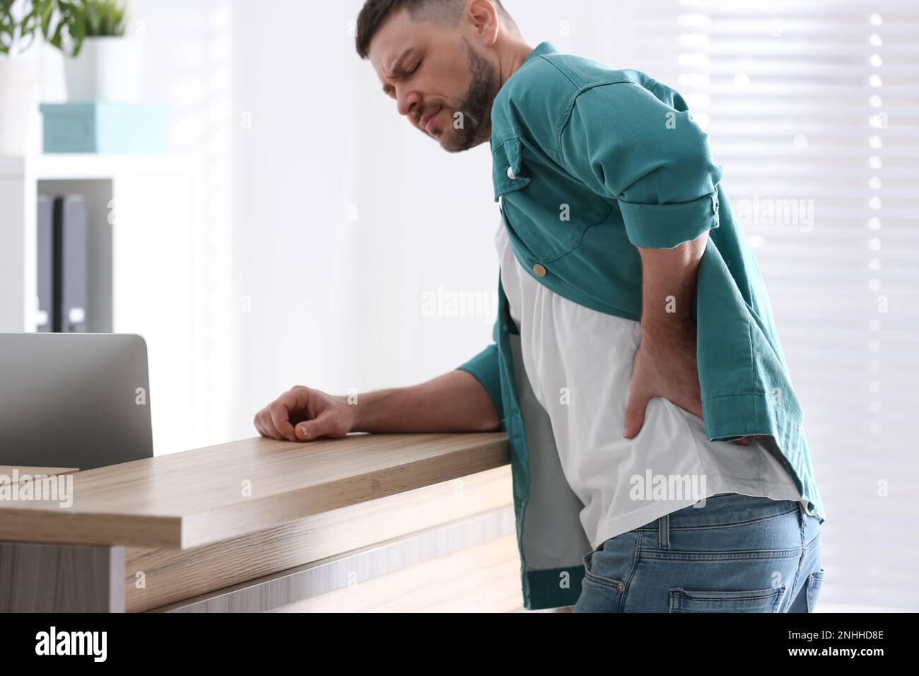 Man suffering from back pain in office. Bad posture problem Stock Photo ...