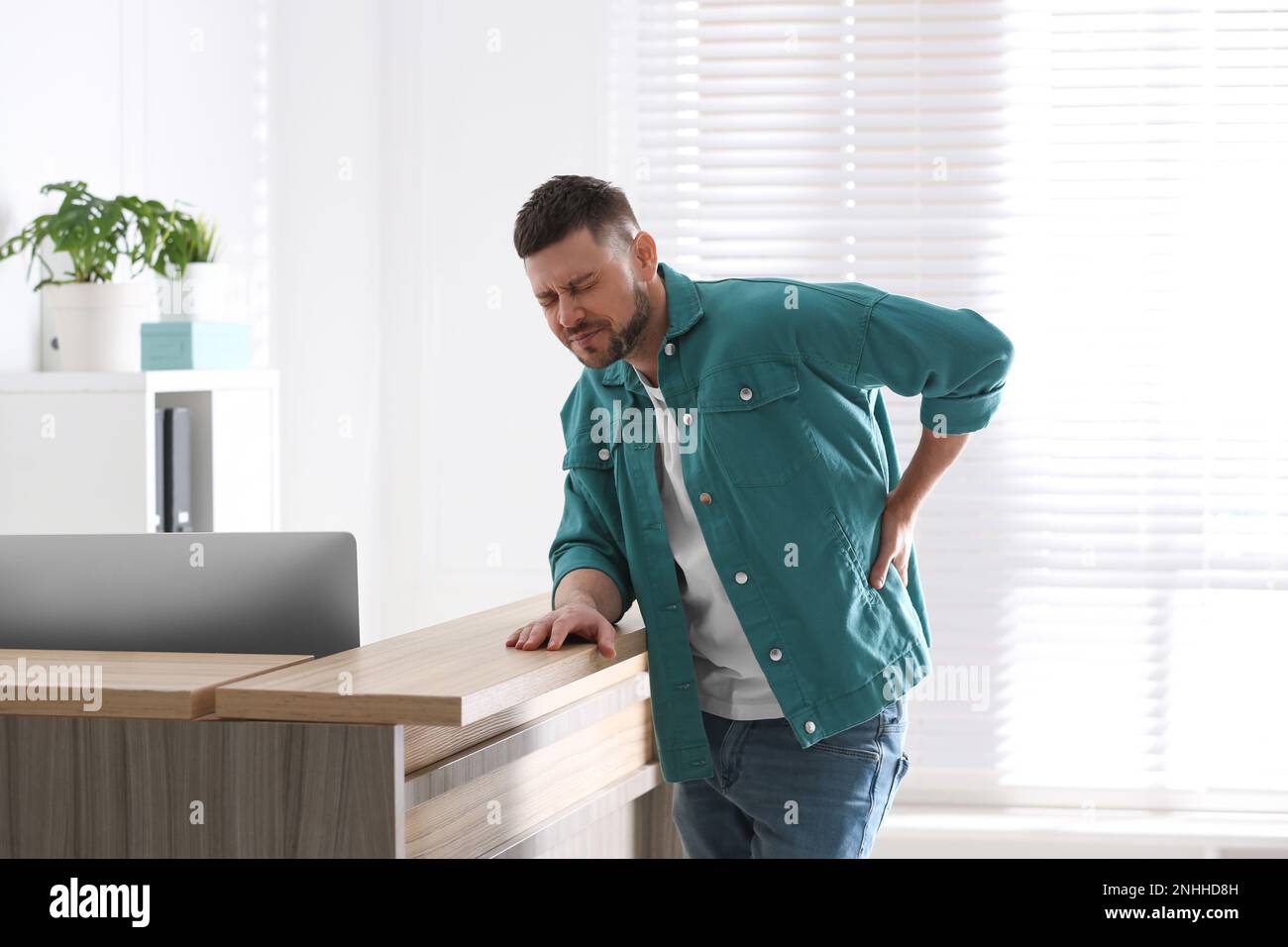 Man suffering from back pain in office. Bad posture problem Stock Photo ...
