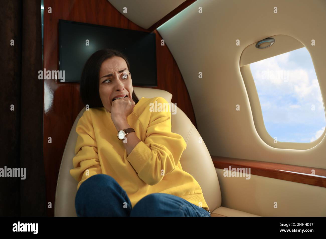 Nervous young woman suffering from aviophobia in airplane Stock Photo ...
